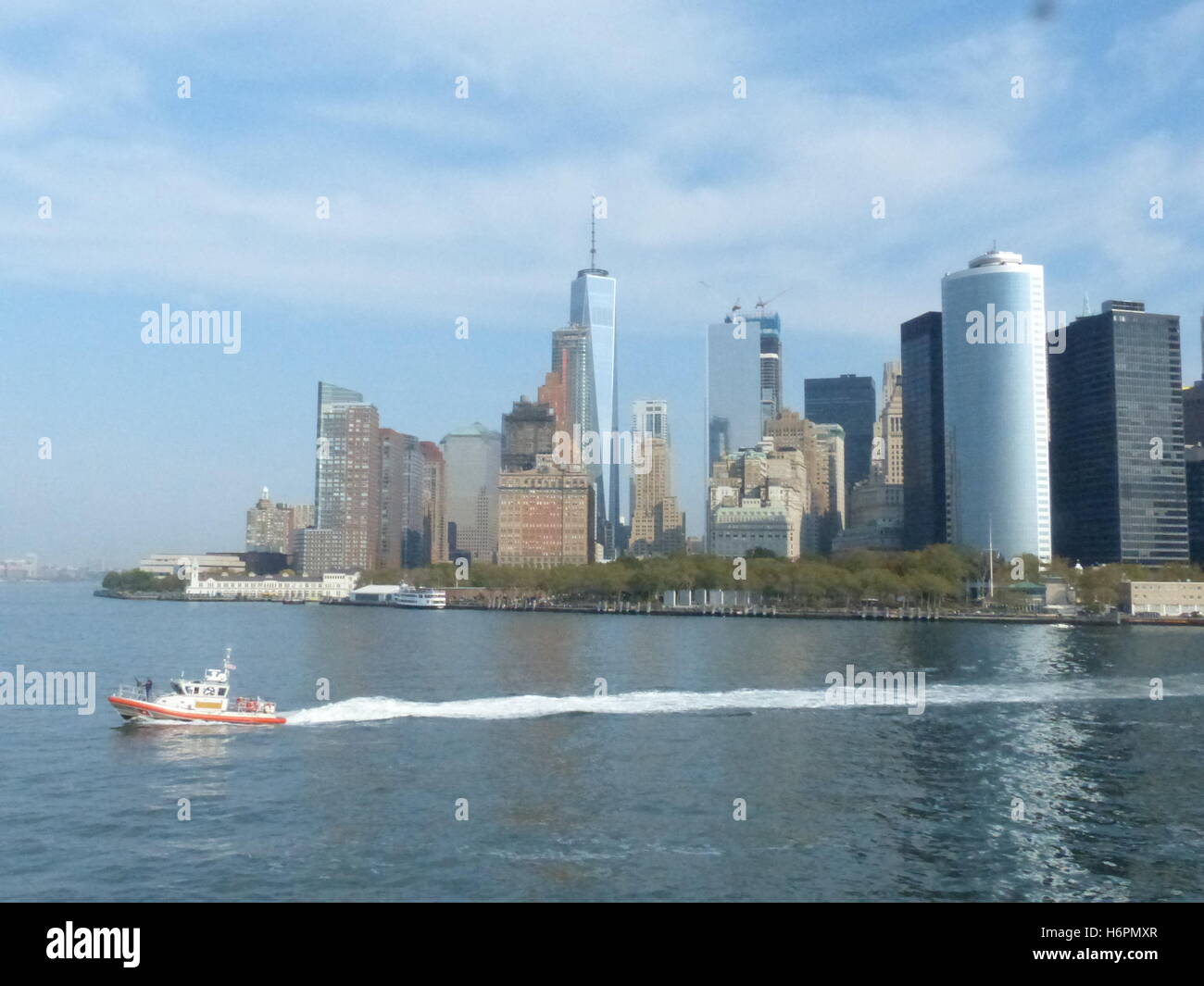 US Coast Guard patrolling New York Harbor with downtown office towers ...