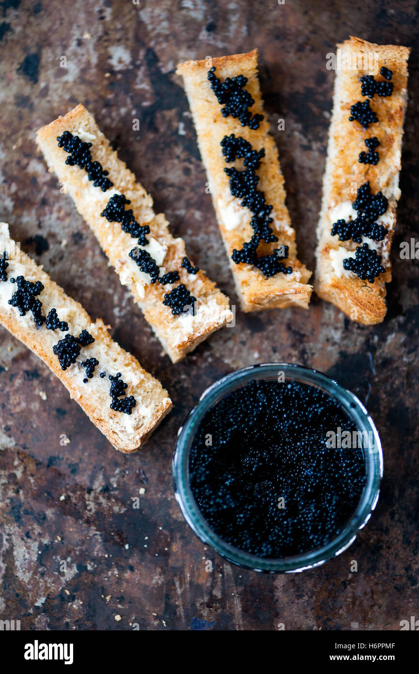 Black caviar on toast with butter Stock Photo - Alamy