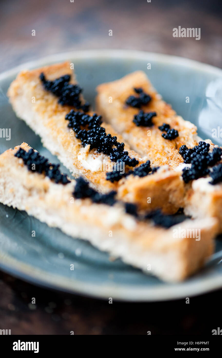 Black caviar on toast with butter Stock Photo - Alamy