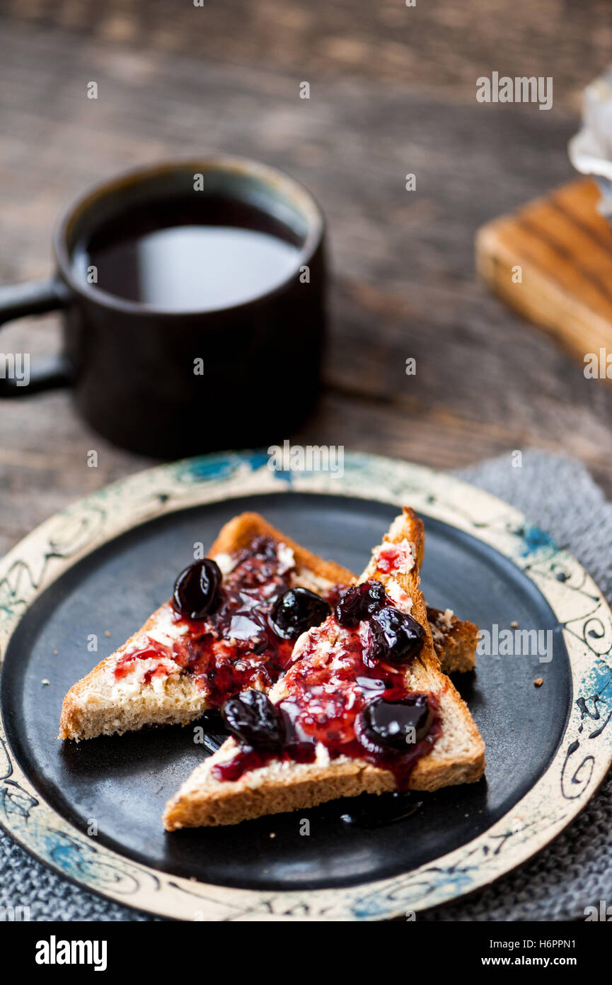 Toast with butter and sour cherry jam for breakfast Stock Photo - Alamy