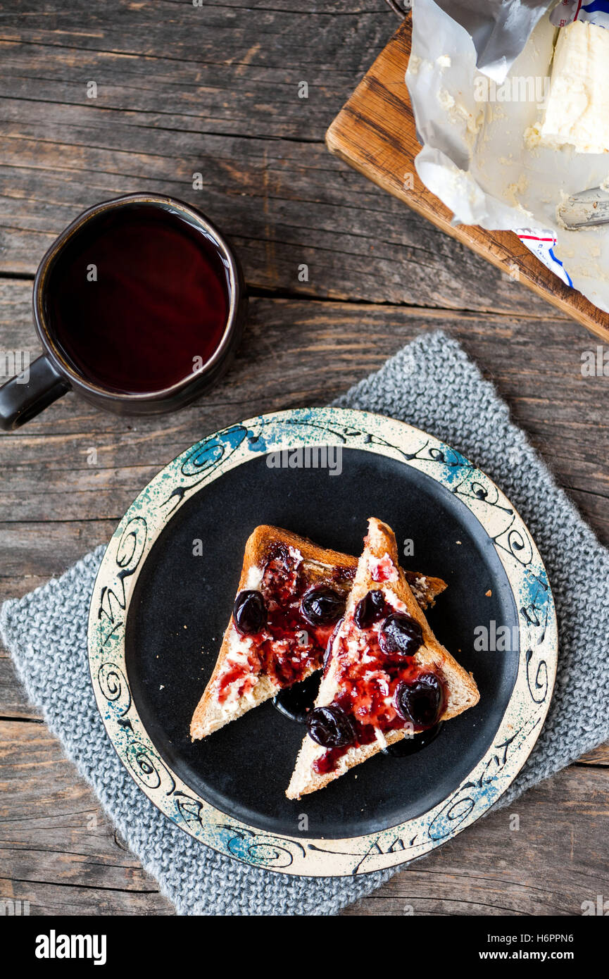 Toast with butter and sour cherry jam for breakfast Stock Photo - Alamy