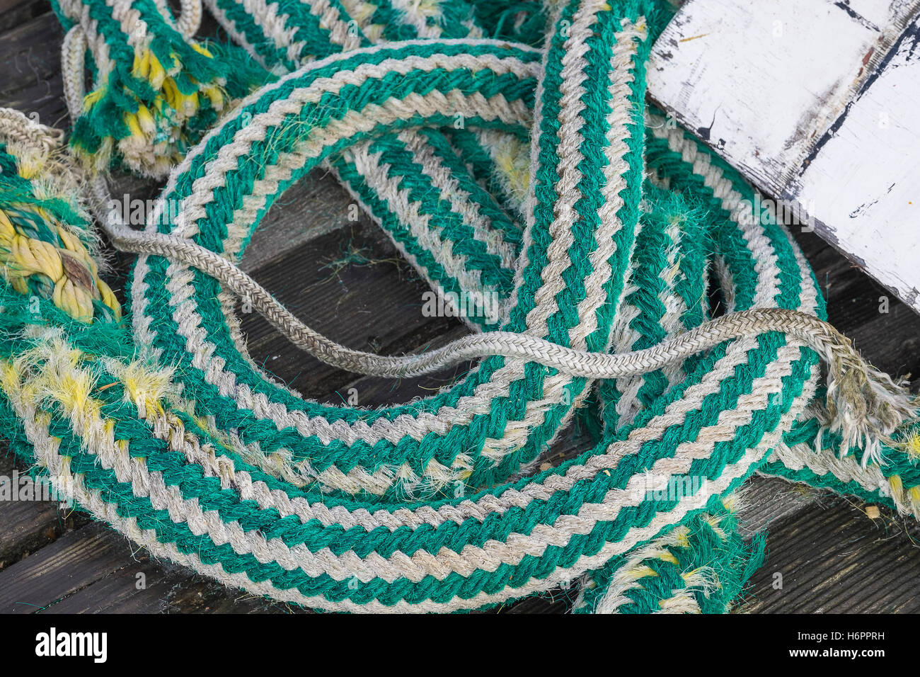 A close view of a green and white rope on a wood dock Stock Photo - Alamy