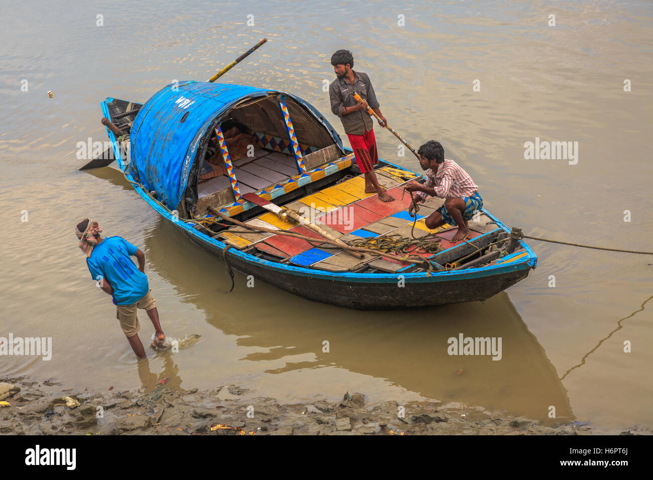 Wooden country boat stuck in mud at low tide on the Ganges river near ...
