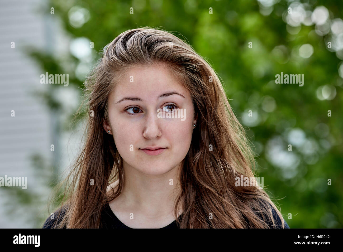 Young Woman expressing contemplation with a smile while gazing off in a ...
