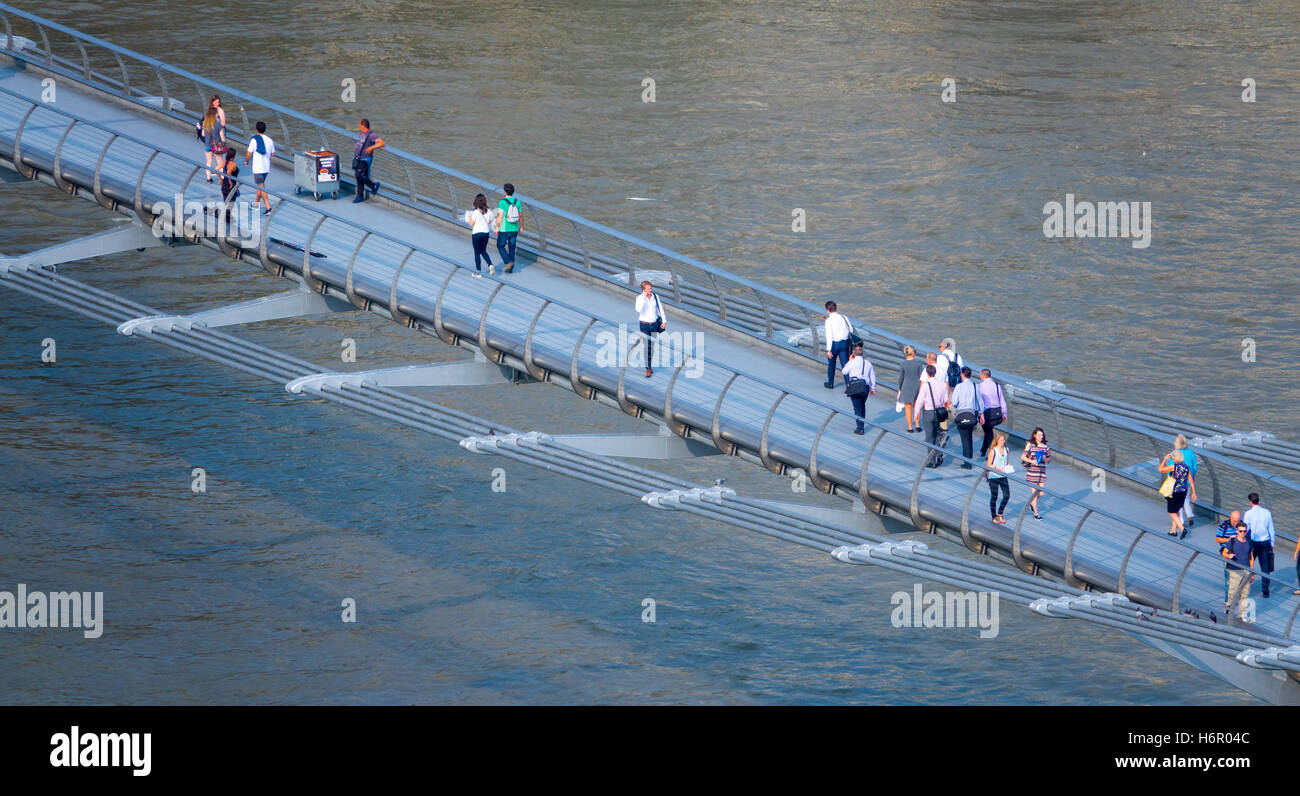 People walking over the Millennium Bridge in London - aerial view Stock ...