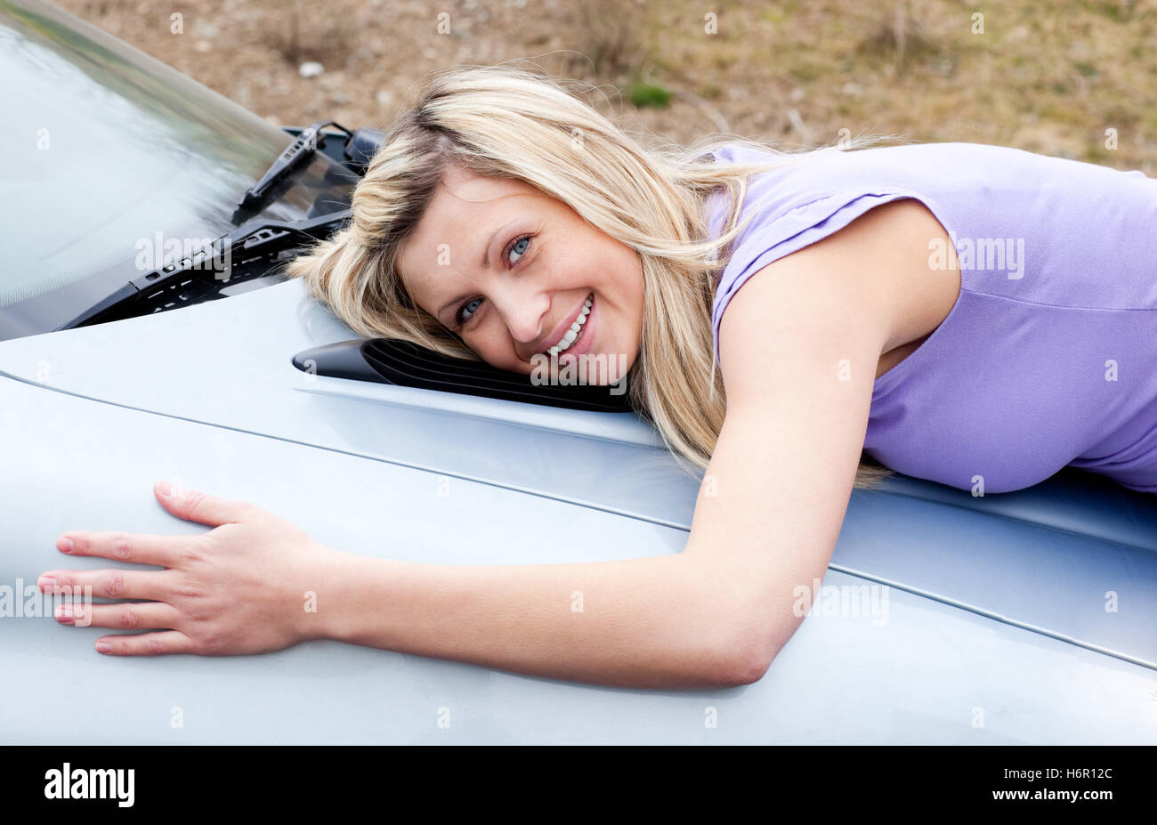 Jolly young female driver huging her new car Stock Photo - Alamy