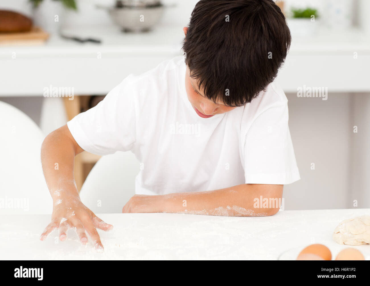 Adorable boy preparing a dough alone in the kitchen Stock Photo - Alamy