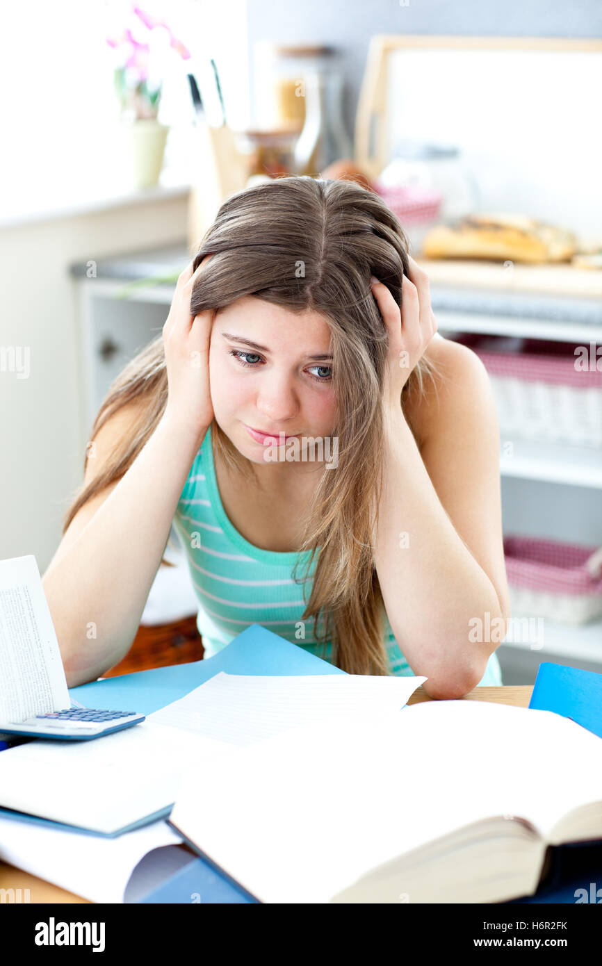 Stressed female teenager studying in the kitchen at home Stock Photo ...