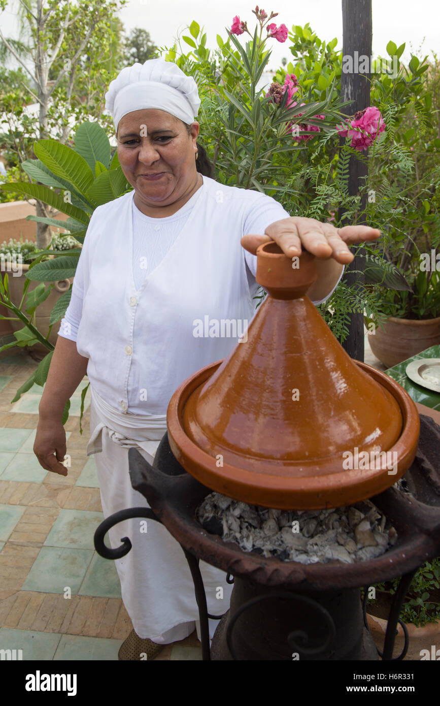 Fouzia, a traditional dada (traditional female chef) at Dar Les Cigognes, cooking a tagine over ...