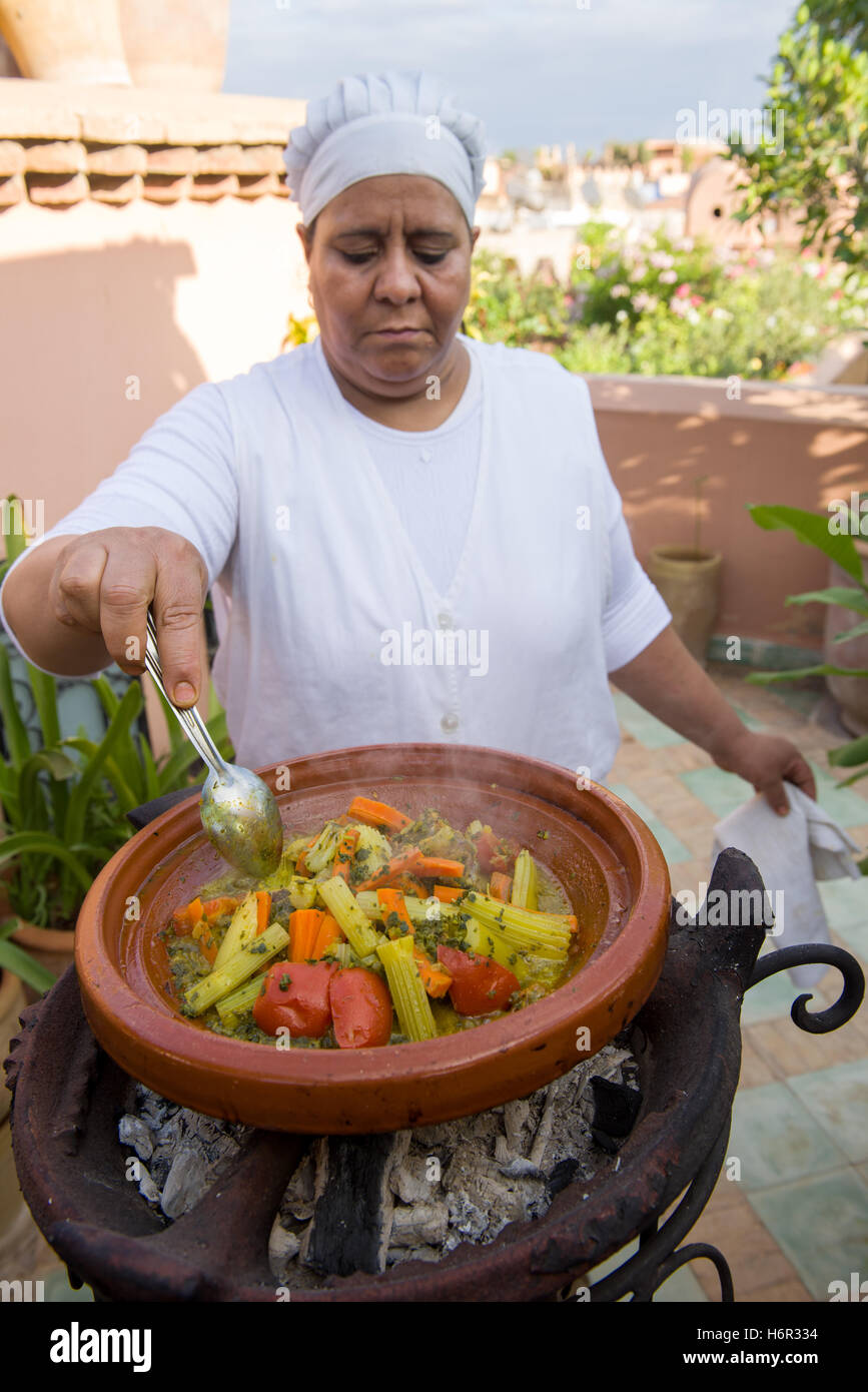 Fouzia, a traditional dada (traditional female chef) at Dar Les Cigognes, cooking a meat tagine ...