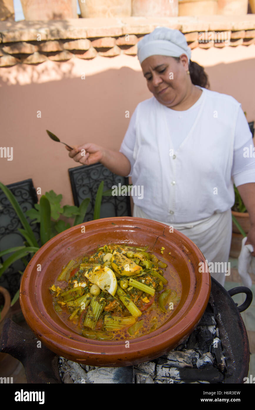 Fouzia, a traditional dada (traditional female chef) at Dar Les Cigognes, cooking a fish tagine ...