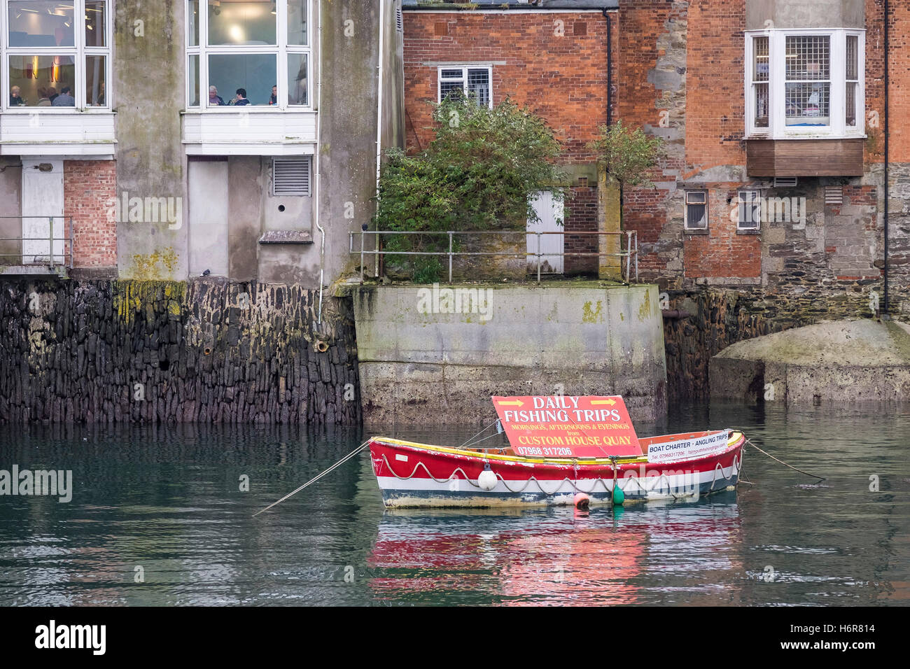 An old dinghy now used for advertising moored in the water behind ...