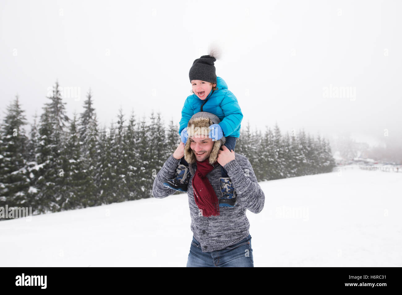 Father giving his son piggyback. Winter nature Stock Photo - Alamy