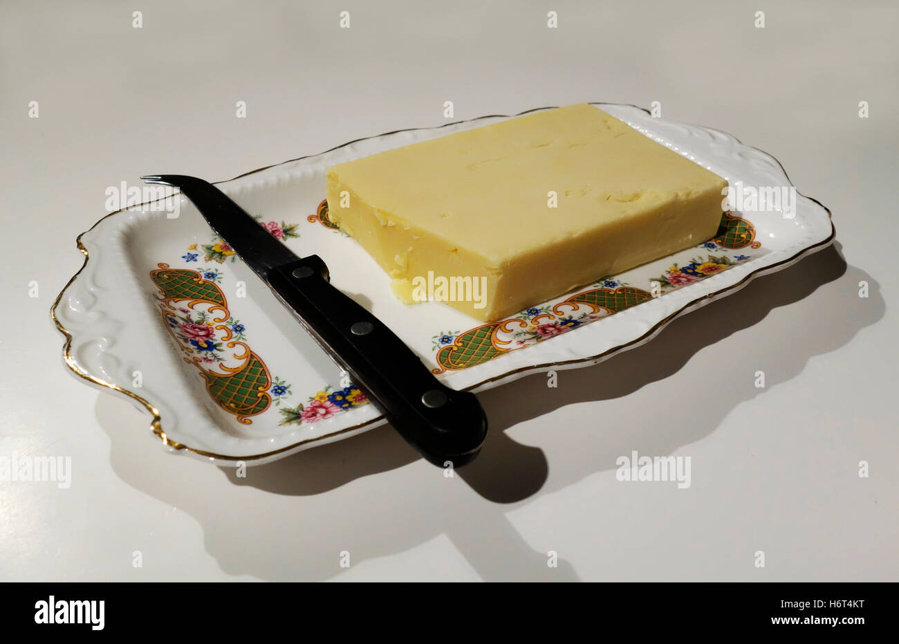 Cheddar Cheese on a plate with a cheese knife Stock Photo - Alamy