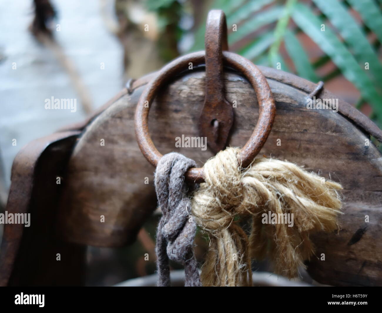 Knots and a metal hoop attached to the top of an old wooden bucket ...