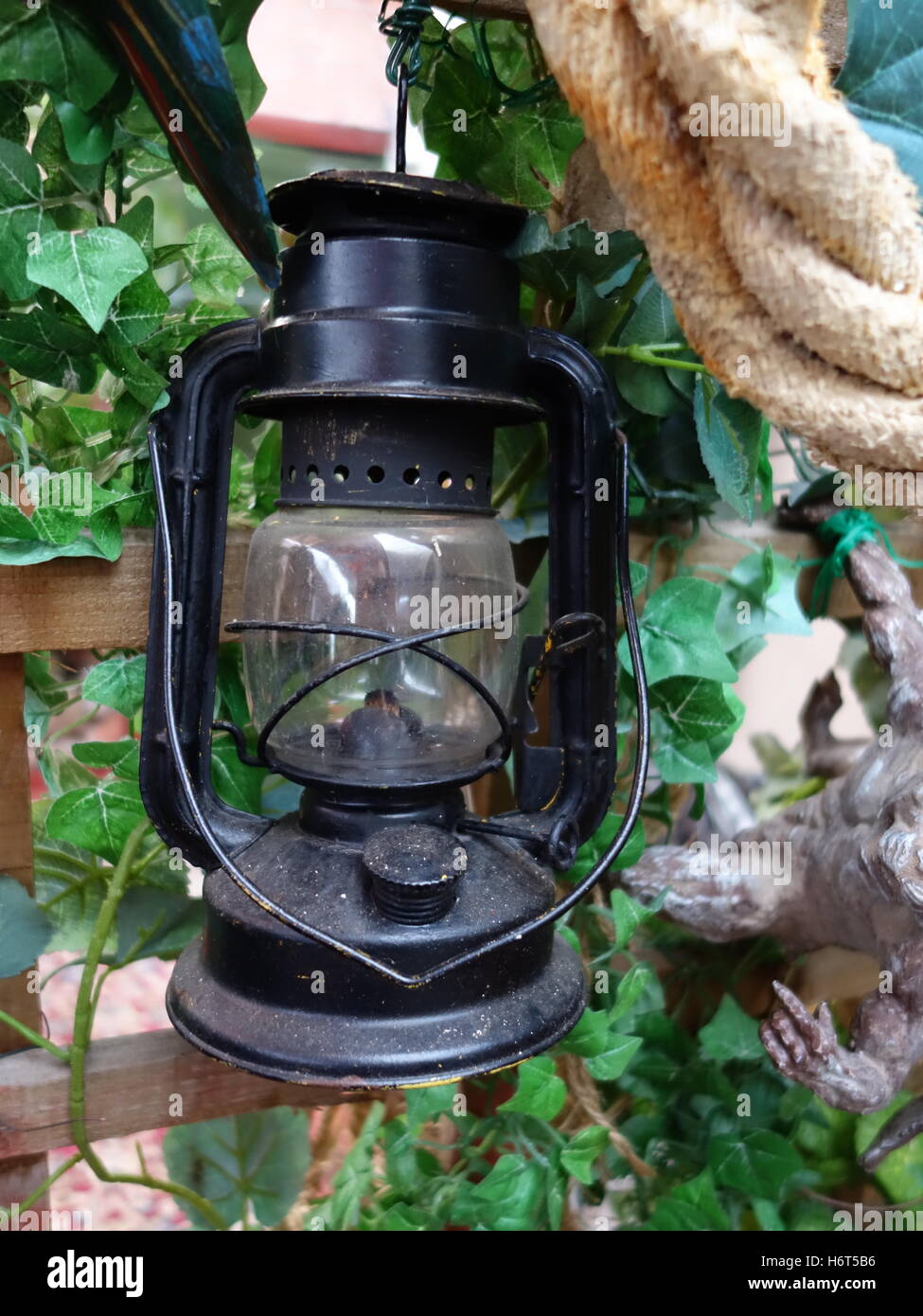 An old lamp hanging on a trellis next to a large ship used rope Stock ...