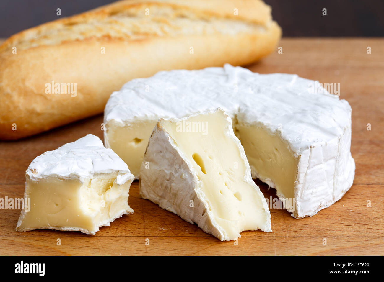 White mould cheese with cut slices half eaten, and baguette, isolated ...