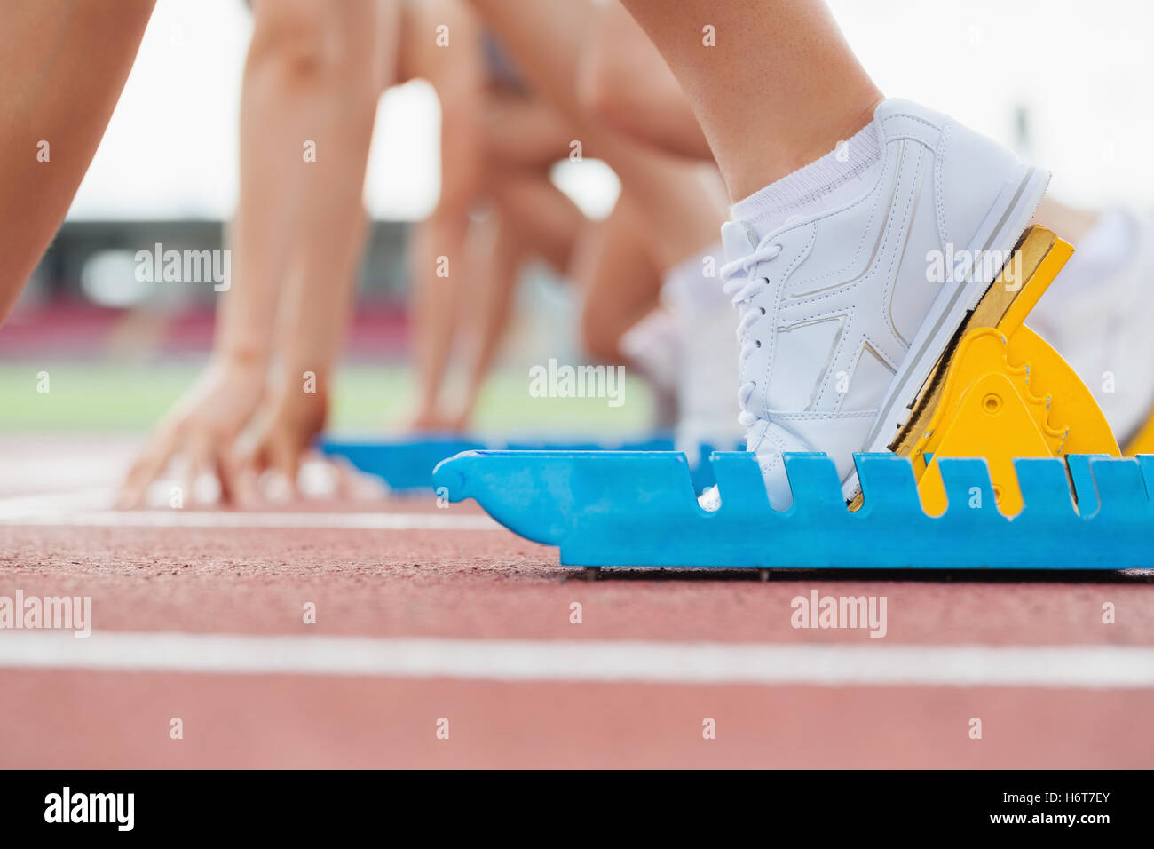 Athletic starting block with runners on track Stock Photo - Alamy