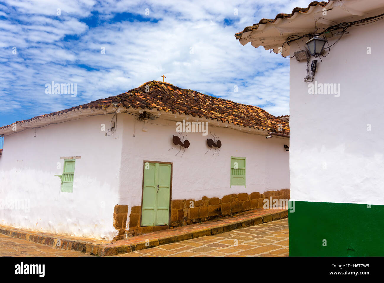 Colonial building on a street corner with large ants on the wall in ...