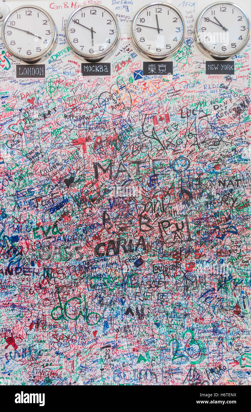 Graffiti wall covered with initials, autographs, hearts, etc. with four ...