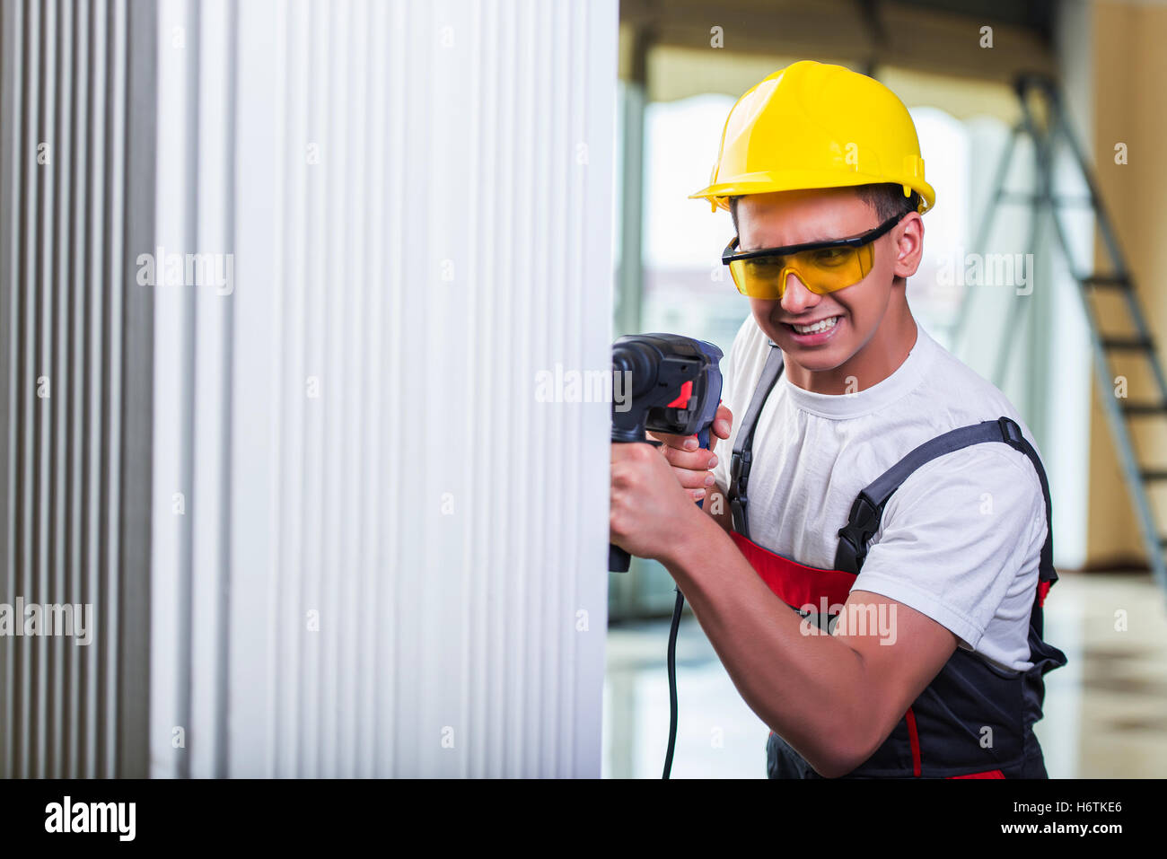 Man drilling the wall with drill perforator Stock Photo - Alamy