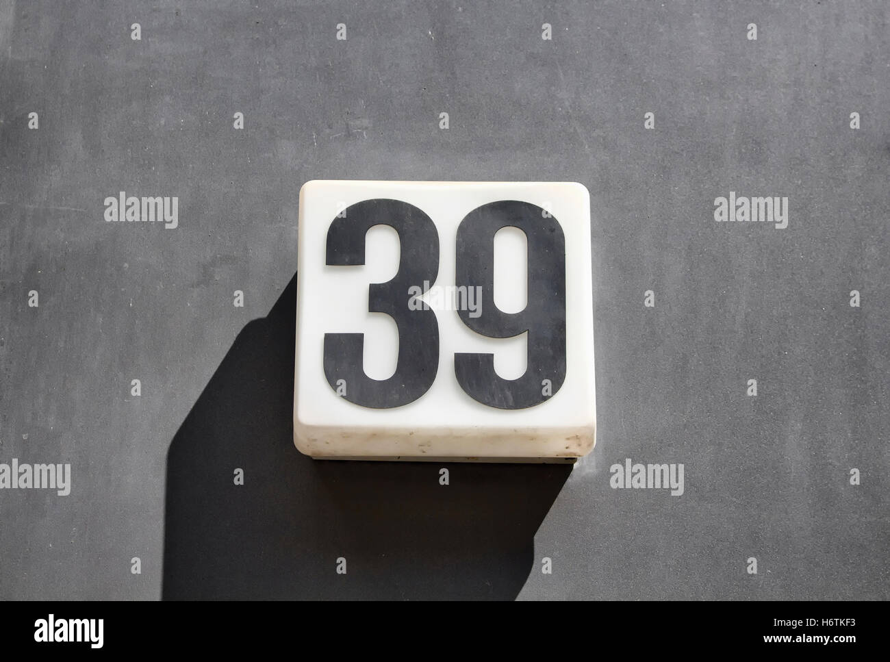 Modern, simple, monochromatic building number on concrete surface in ...