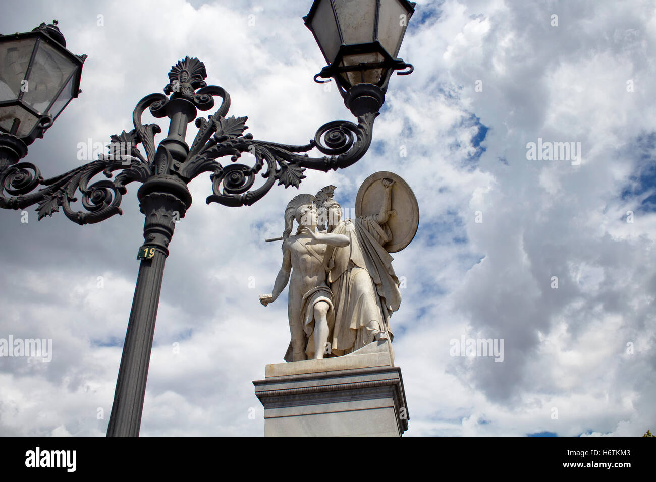 Old, historical street lamp with soldiers statue and cloudy sky in the ...