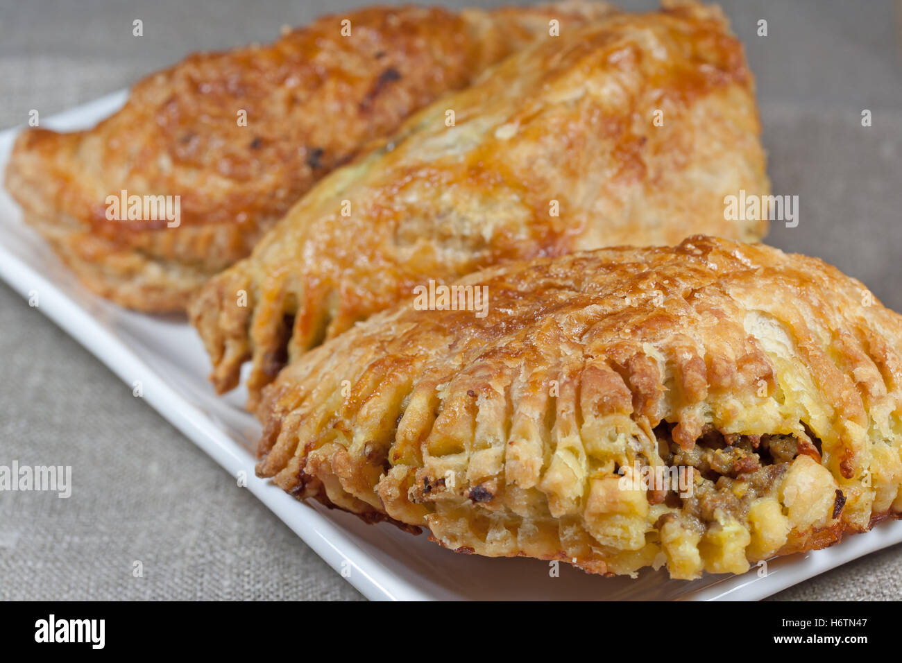 pierogi with mince filled on a white plate with beige background Stock ...