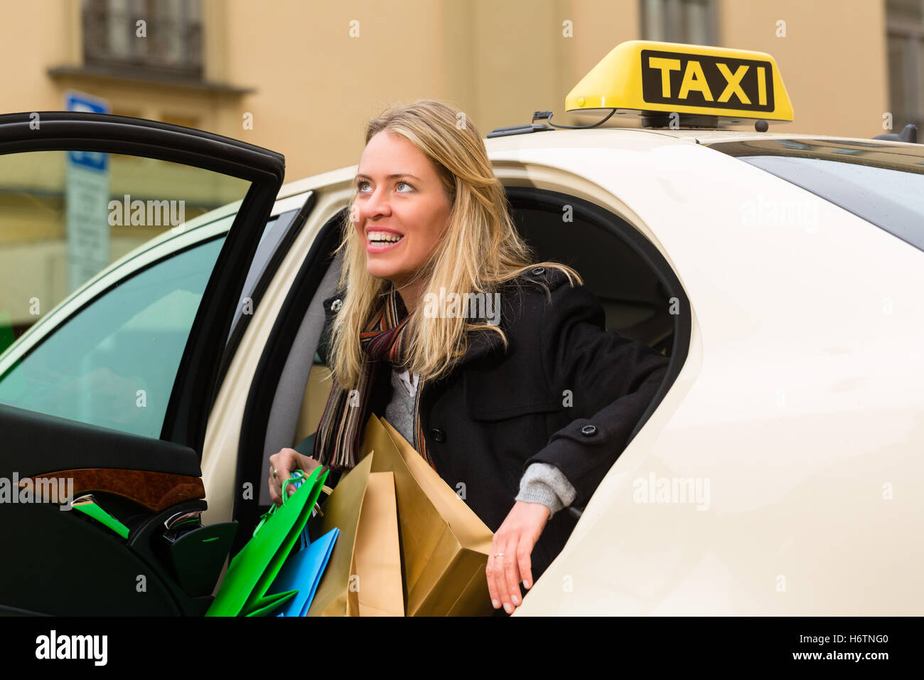 a young woman gets out of a taxi Stock Photo - Alamy