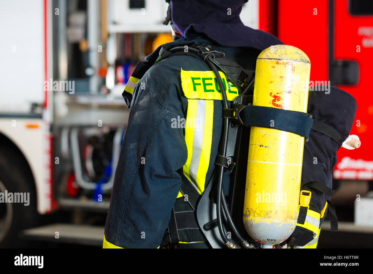 firefighter standing in uniform in front of a fire Stock Photo - Alamy