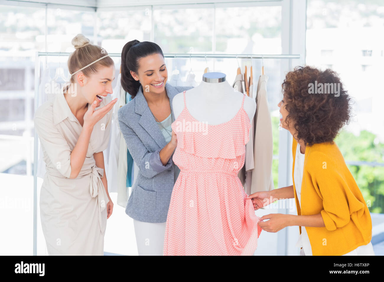 Attractive fashion designers looking at a dress on a mannequin Stock ...