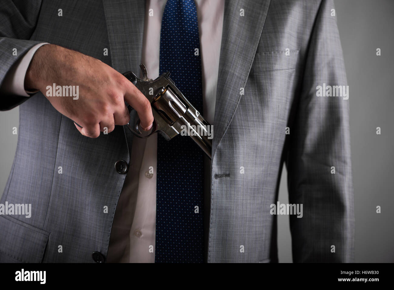 Man pulling out gun from his pocket Stock Photo - Alamy