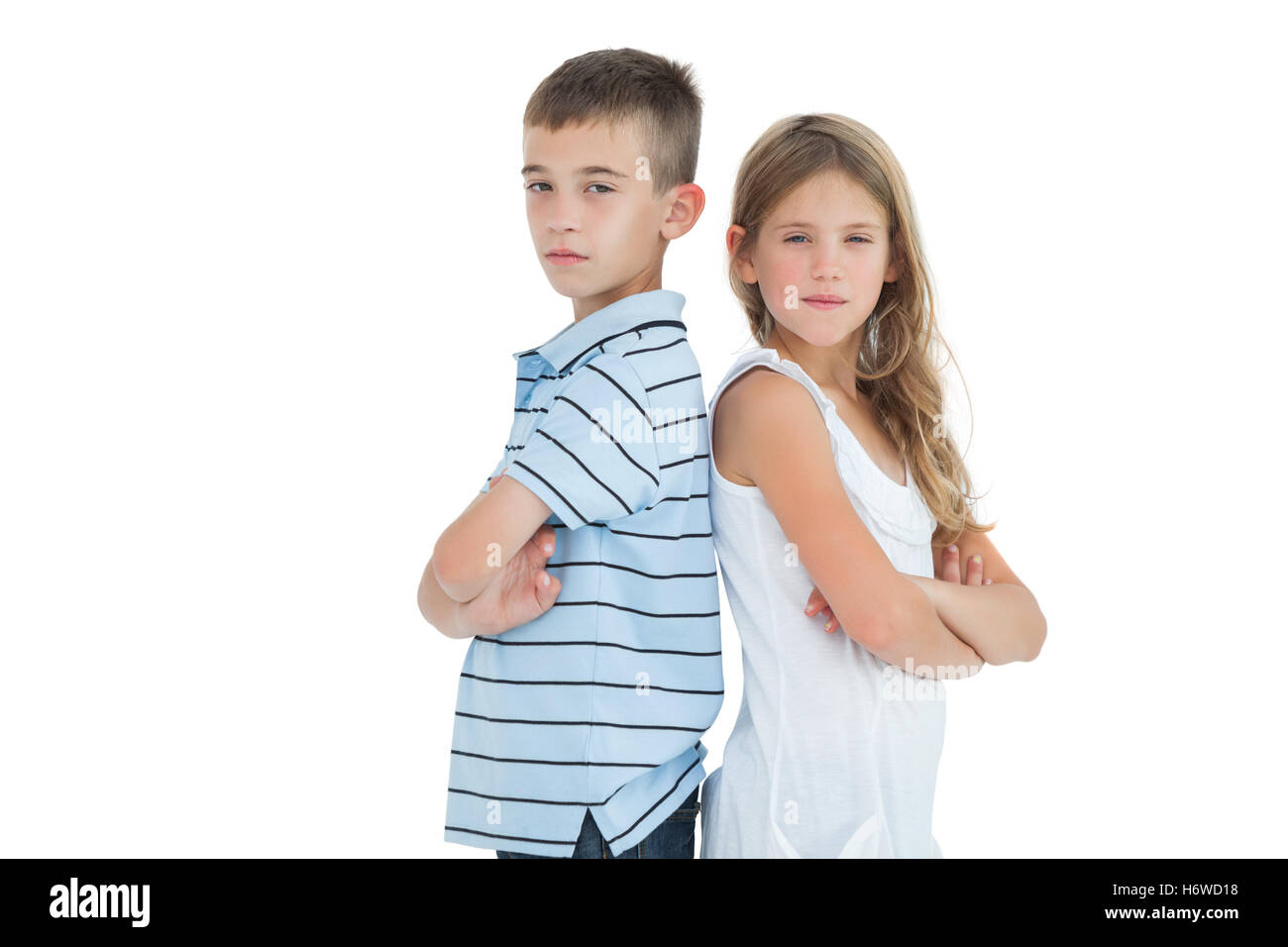 Serious young brother and sister posing back to back on white ...