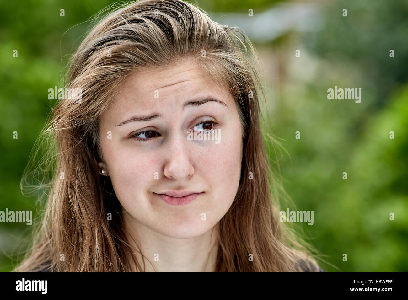 Head shot of a girl with a suspicious expression Stock Photo - Alamy