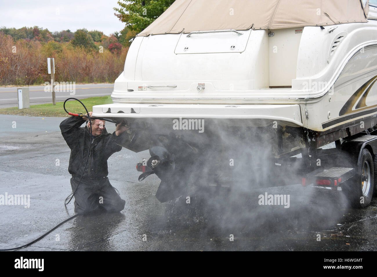 Caucasian man cleaning power boat with pressure washer Stock Photo - Alamy
