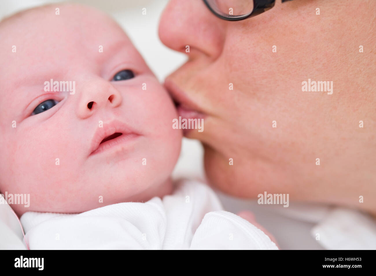 Mother kissing baby on cheek Stock Photo - Alamy