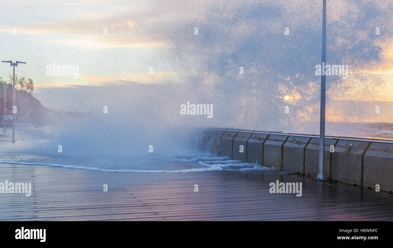 Huge wave breaks over pier creating large splashes at Sunset. Melbourne ...