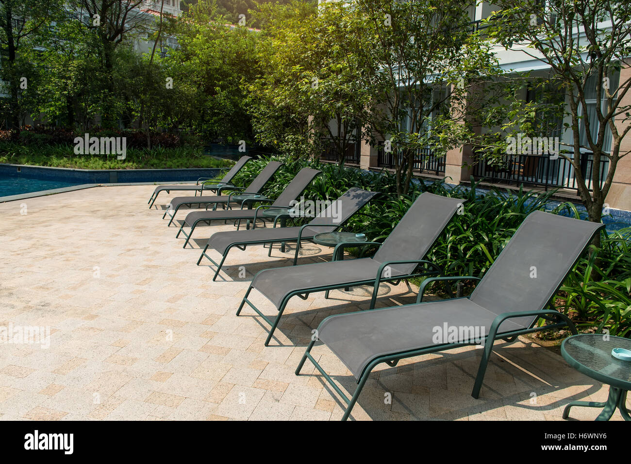 Swimming pool with beach chairs Stock Photo - Alamy