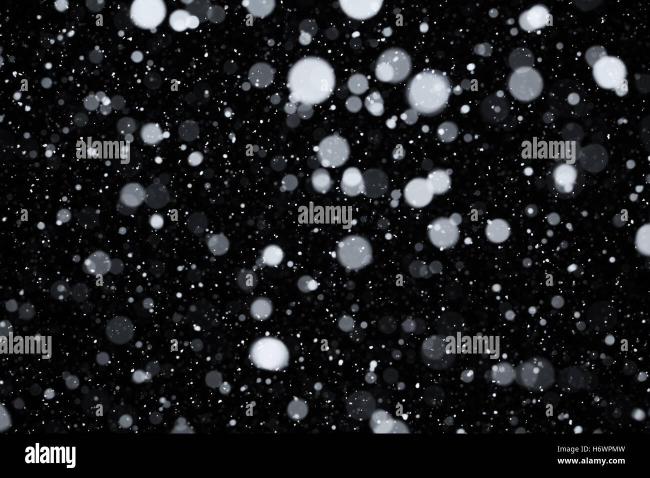 Falling snow on black background Stock Photo - Alamy