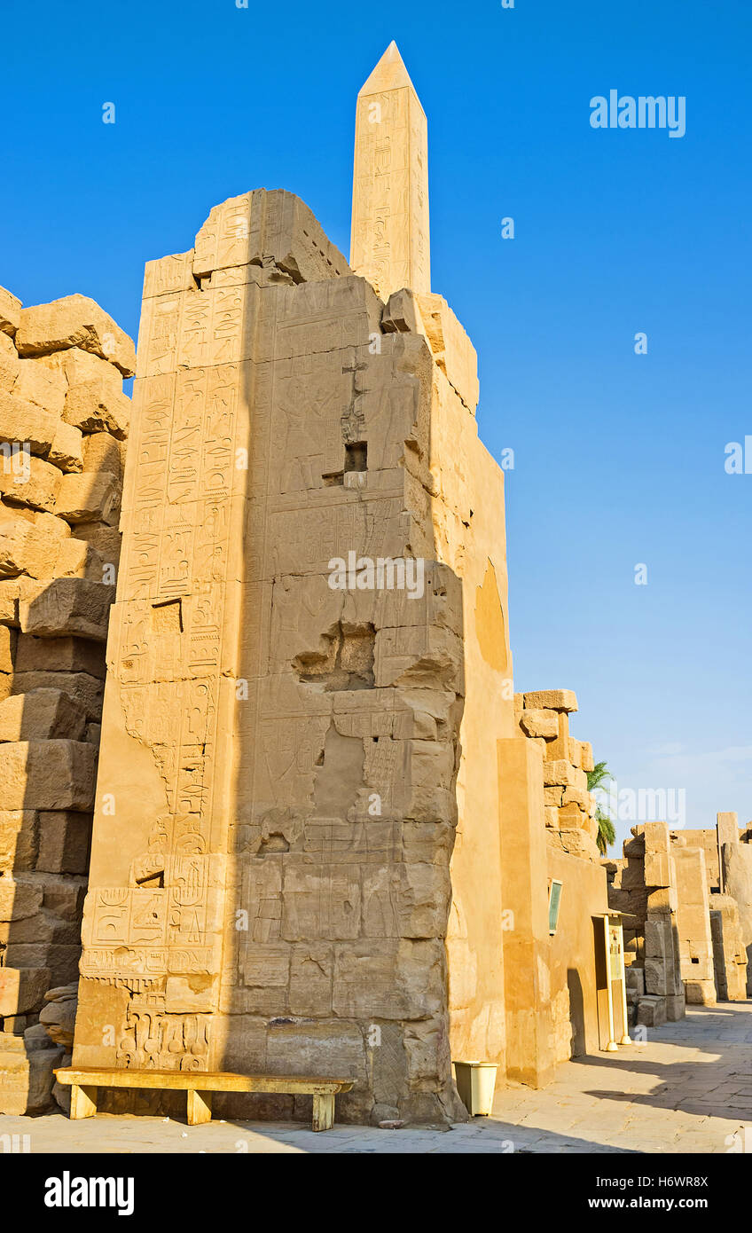 The top of the Hatshepsut Obelisk is seen behind the ruined wall of the ...