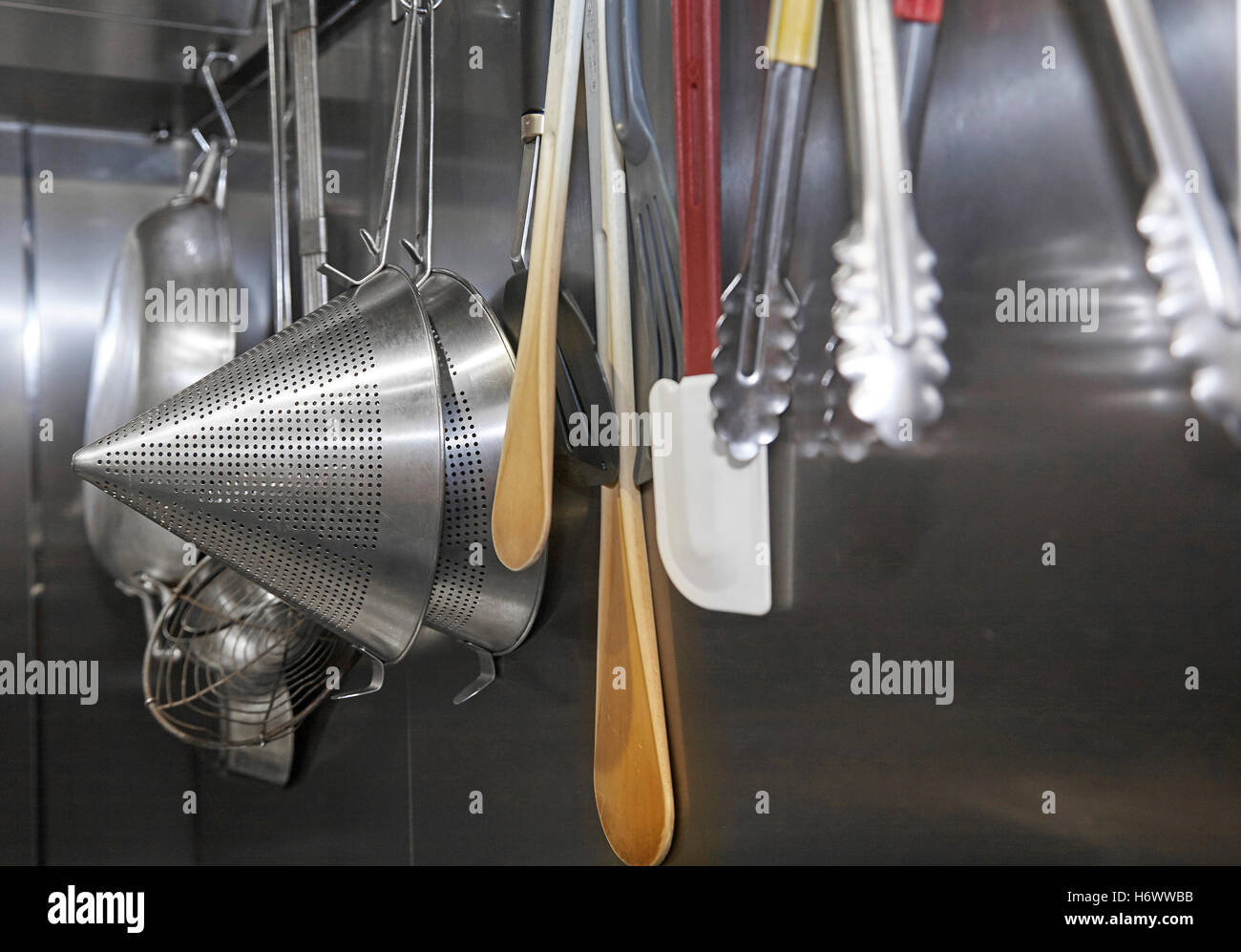 Utensils hanging up in a professional kitchen Stock Photo - Alamy