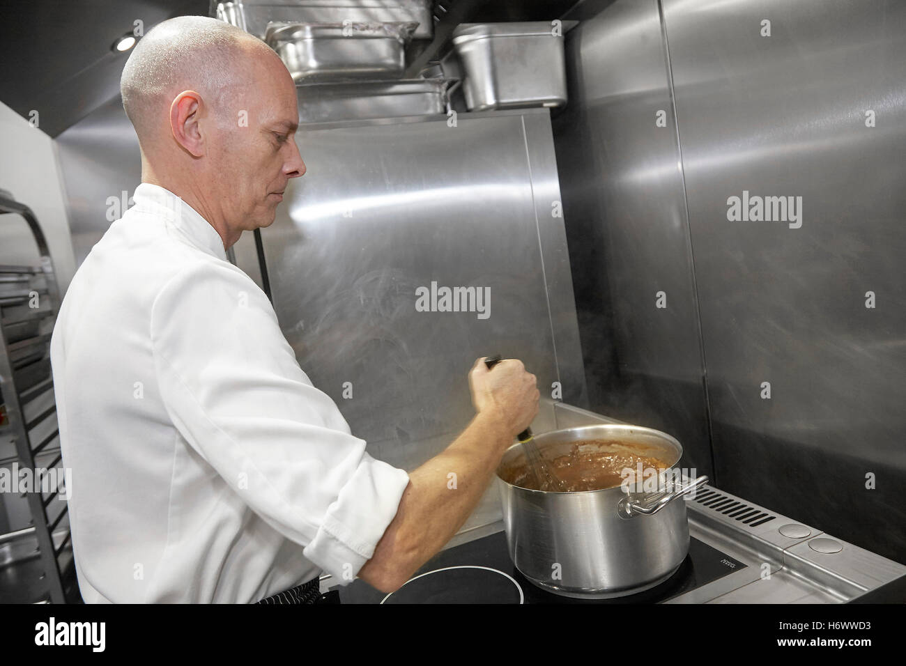 Chef Stirring food in a commercial kitchen in the UK Stock Photo - Alamy