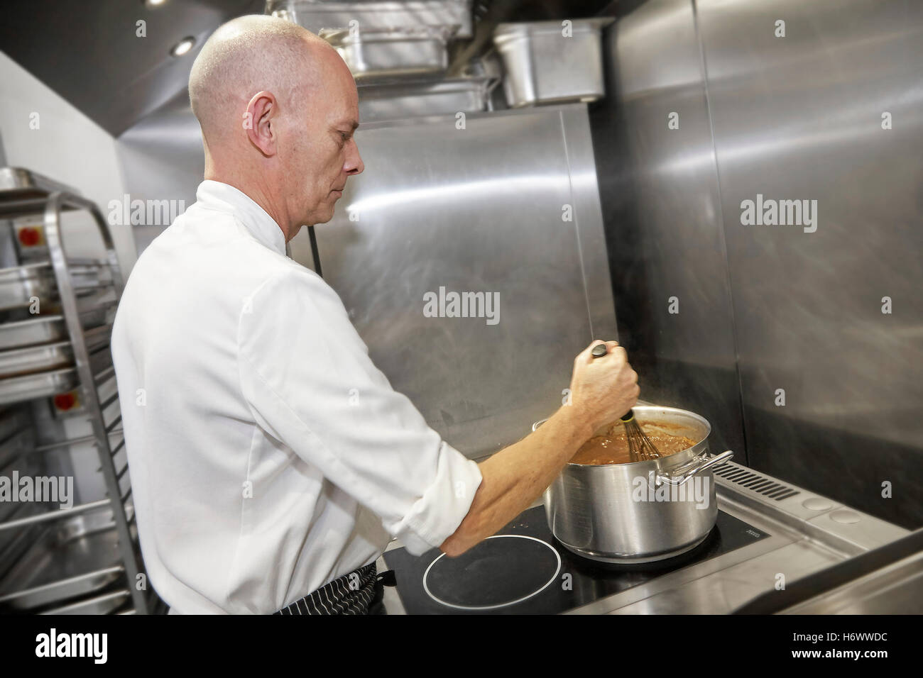 Chef Stirring food in a commercial kitchen in the UK Stock Photo - Alamy