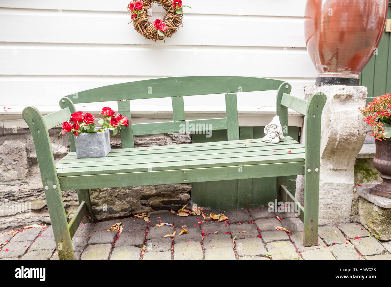 an old wooden bench in the street with a pot at a building Stock Photo ...