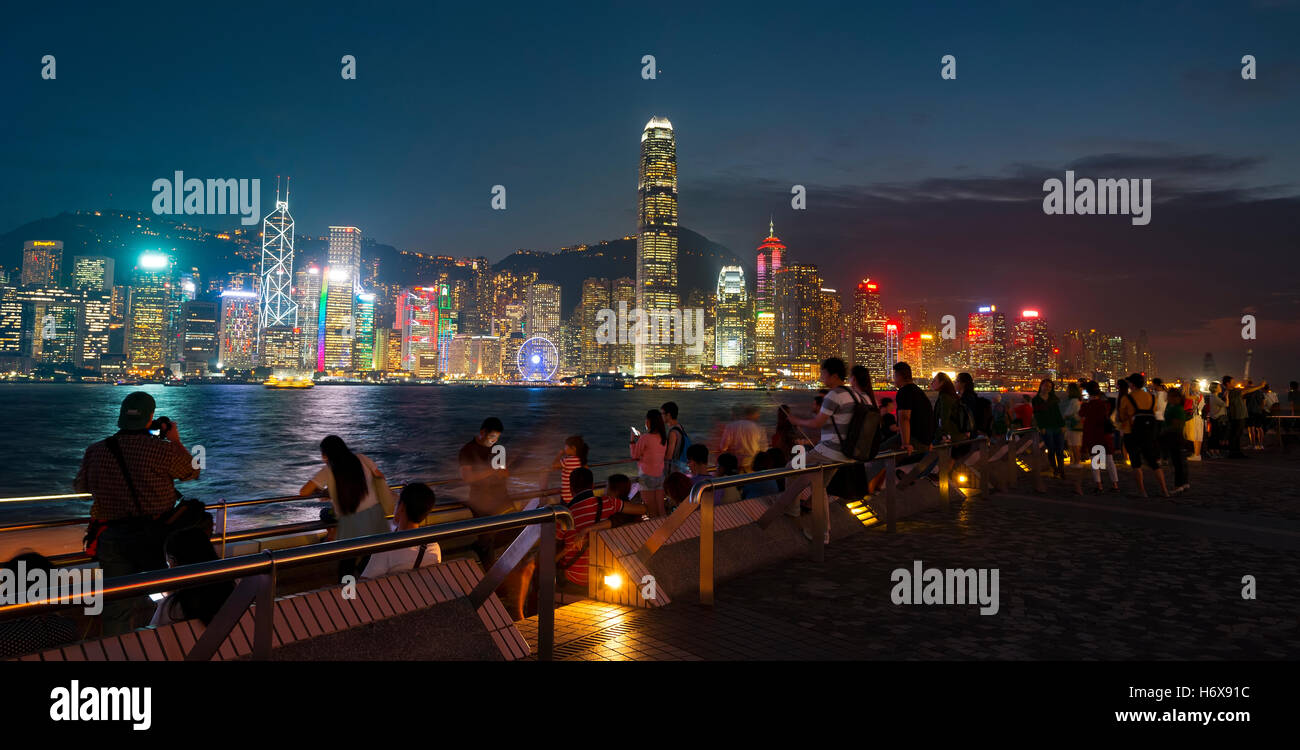 The famous Tsim Sha Tsui promenade, and tourists enjoying the evening view of Hong Kong Island ...