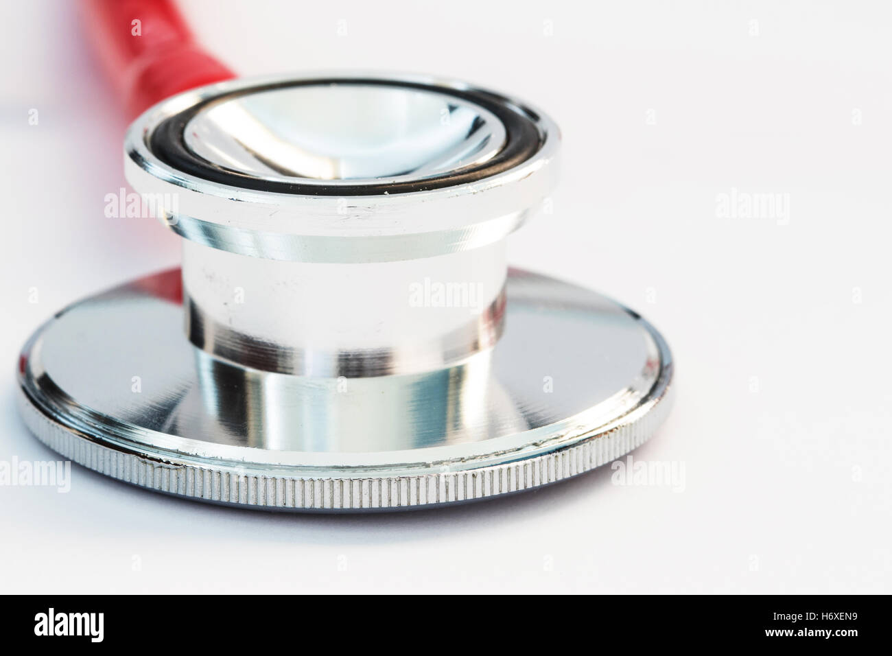 Close up of a silver stethoscope with red tubing on a white background ...