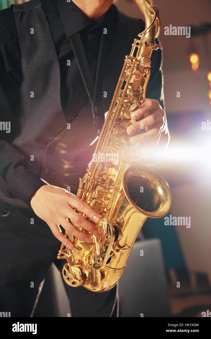 Young man in a suit hold saxophone Stock Photo - Alamy