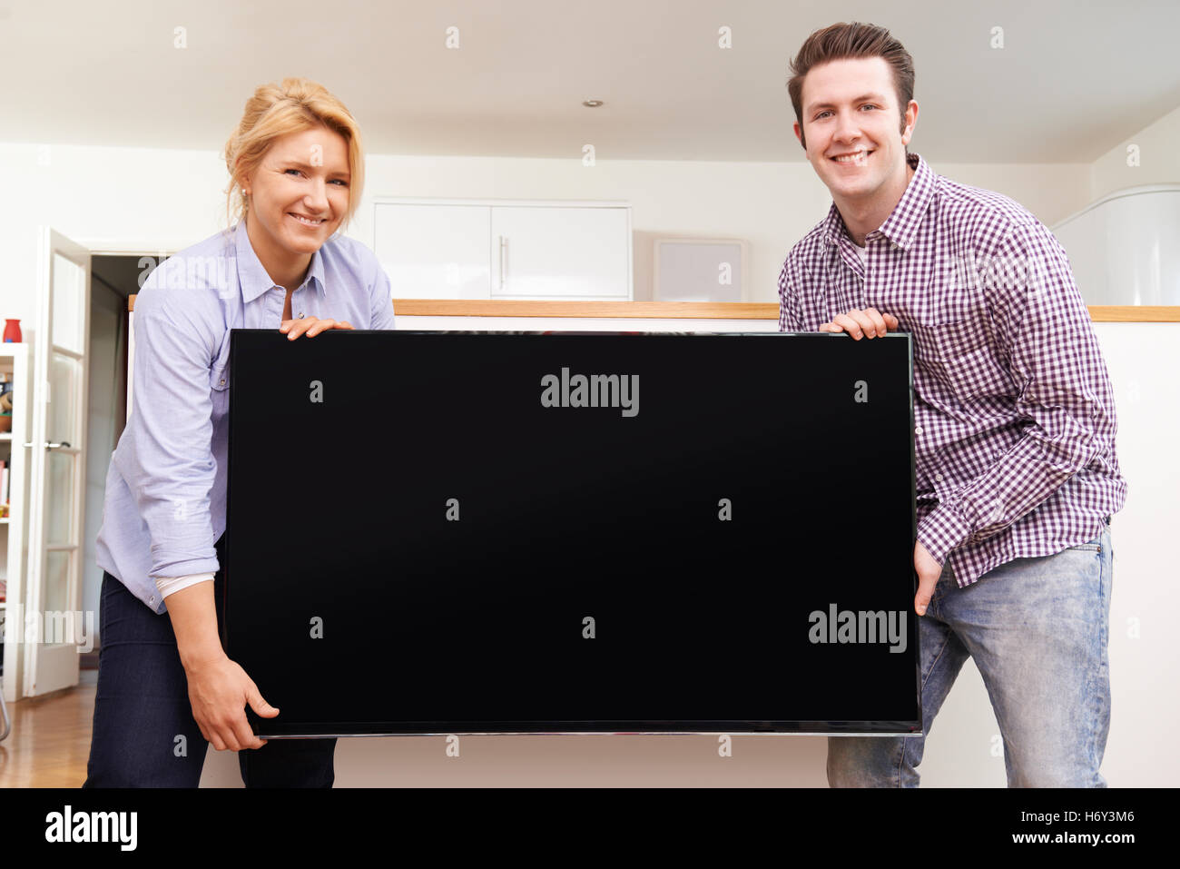 Excited Couple Setting Up New Television At Home Stock Photo - Alamy