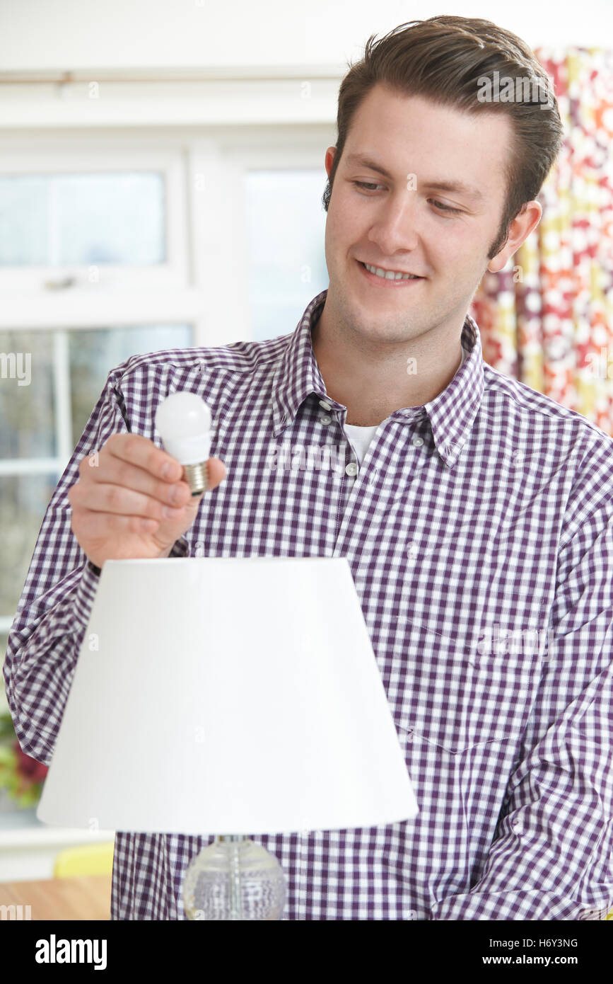 Man Putting Low Energy LED Lightbulb Into Lamp At Home Stock Photo - Alamy