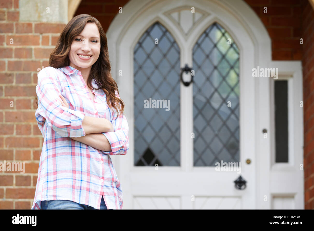 Portrait Of Woman Standing Outside Front Door Of Home Stock Photo - Alamy